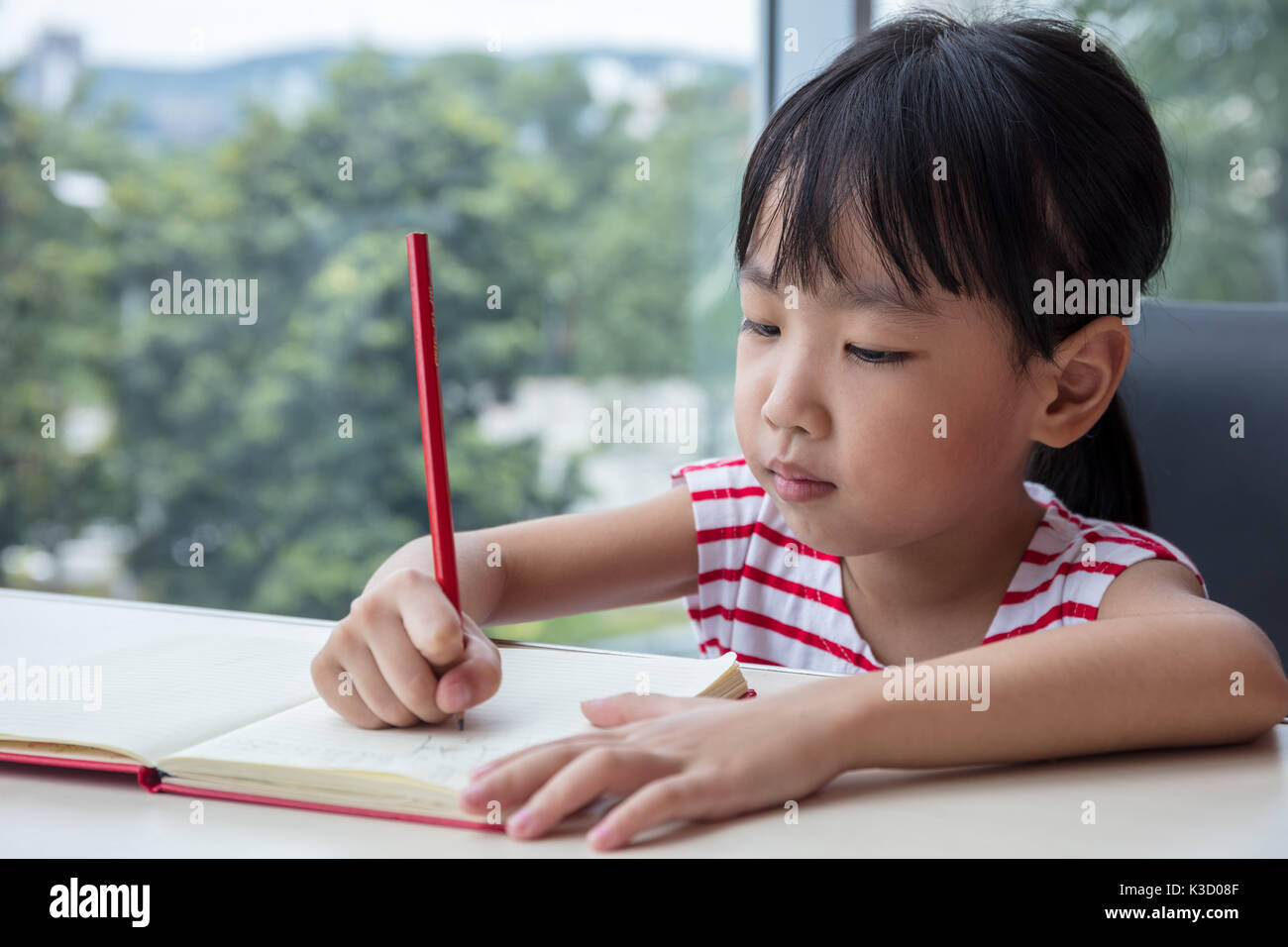 Asian little Chinese girl writing homework at home Stock Photo - Alamy