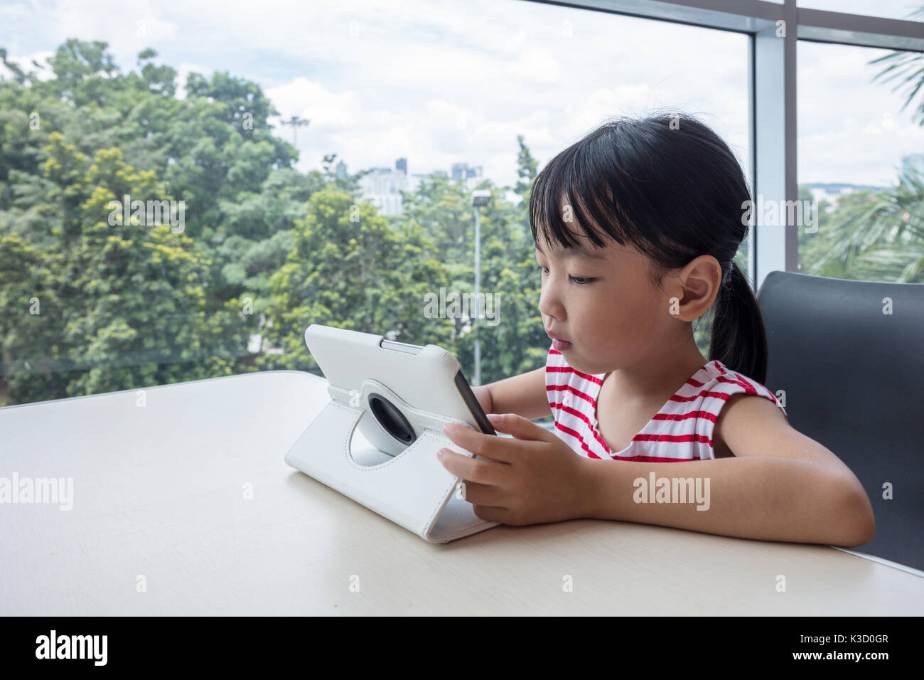 Asian Chinese little girl playing tablet computer at home Stock Photo ...