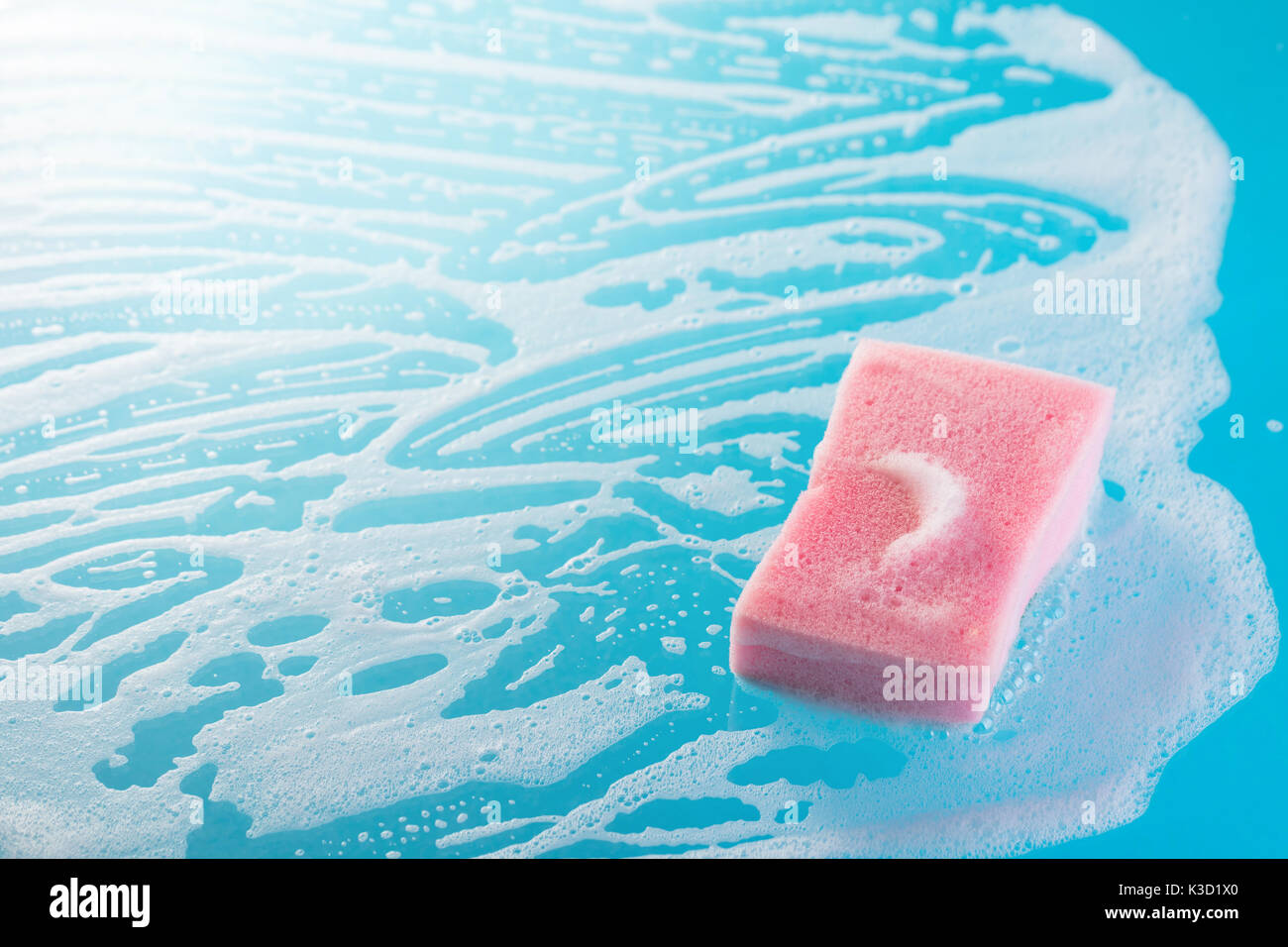 Cleaning concept, sponge in foam on a blue background Stock Photo - Alamy