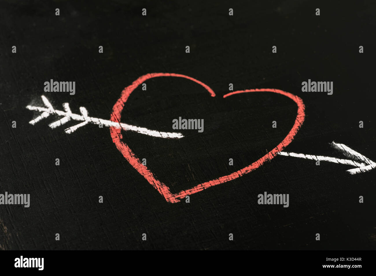 heart and arrow chalk drawing on blackboard background selective focus ...