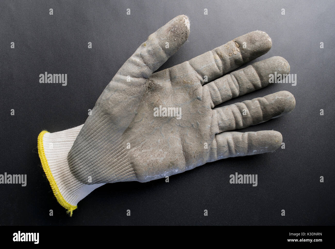 Isolated worn out working gloves against a black surface Stock Photo ...