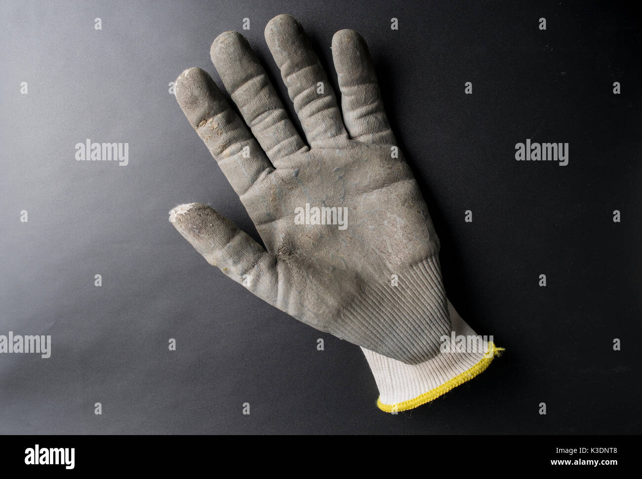 Isolated worn out working gloves against a black surface Stock Photo ...
