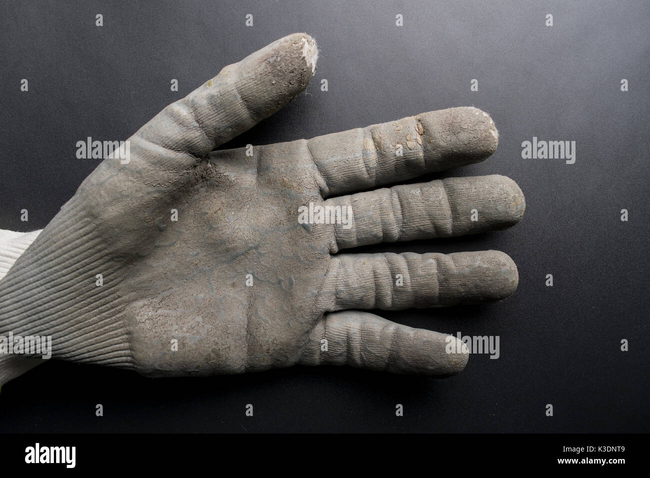 Isolated worn out working gloves against a black surface Stock Photo ...