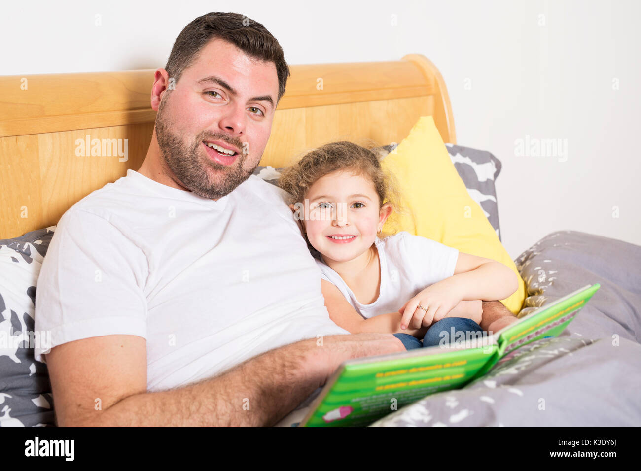 Father reading a story to his daughter at home hi-res stock photography ...