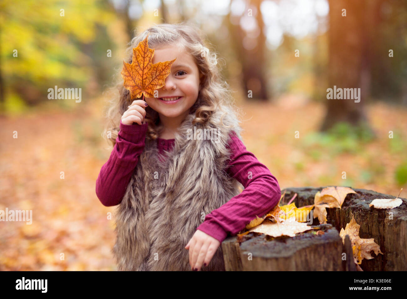 Adorable little girl in a autumn forest Stock Photo - Alamy