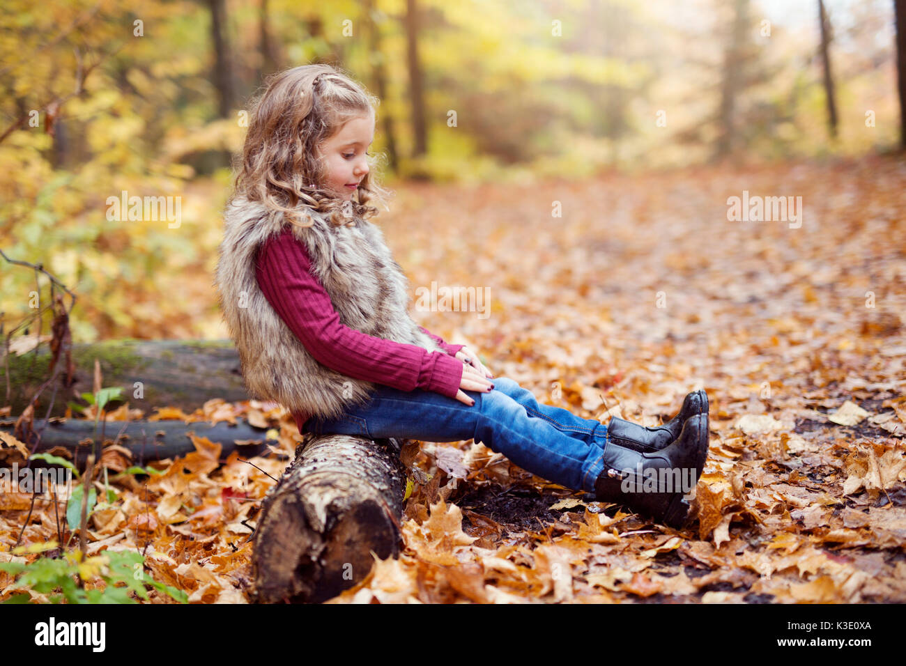 Adorable little girl in a autumn forest Stock Photo - Alamy