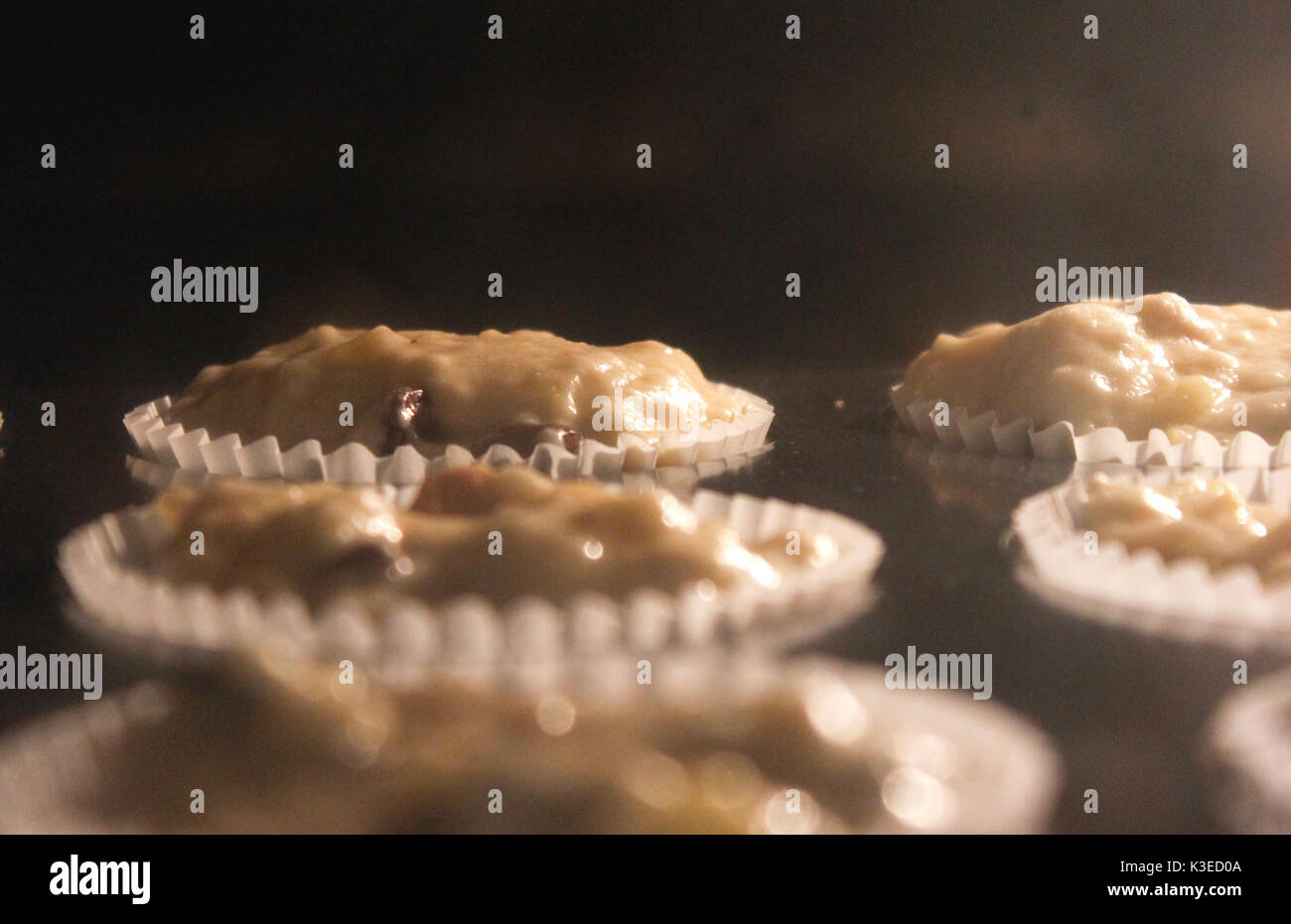 batter for muffins rising inside the oven as muffins bake Stock Photo ...