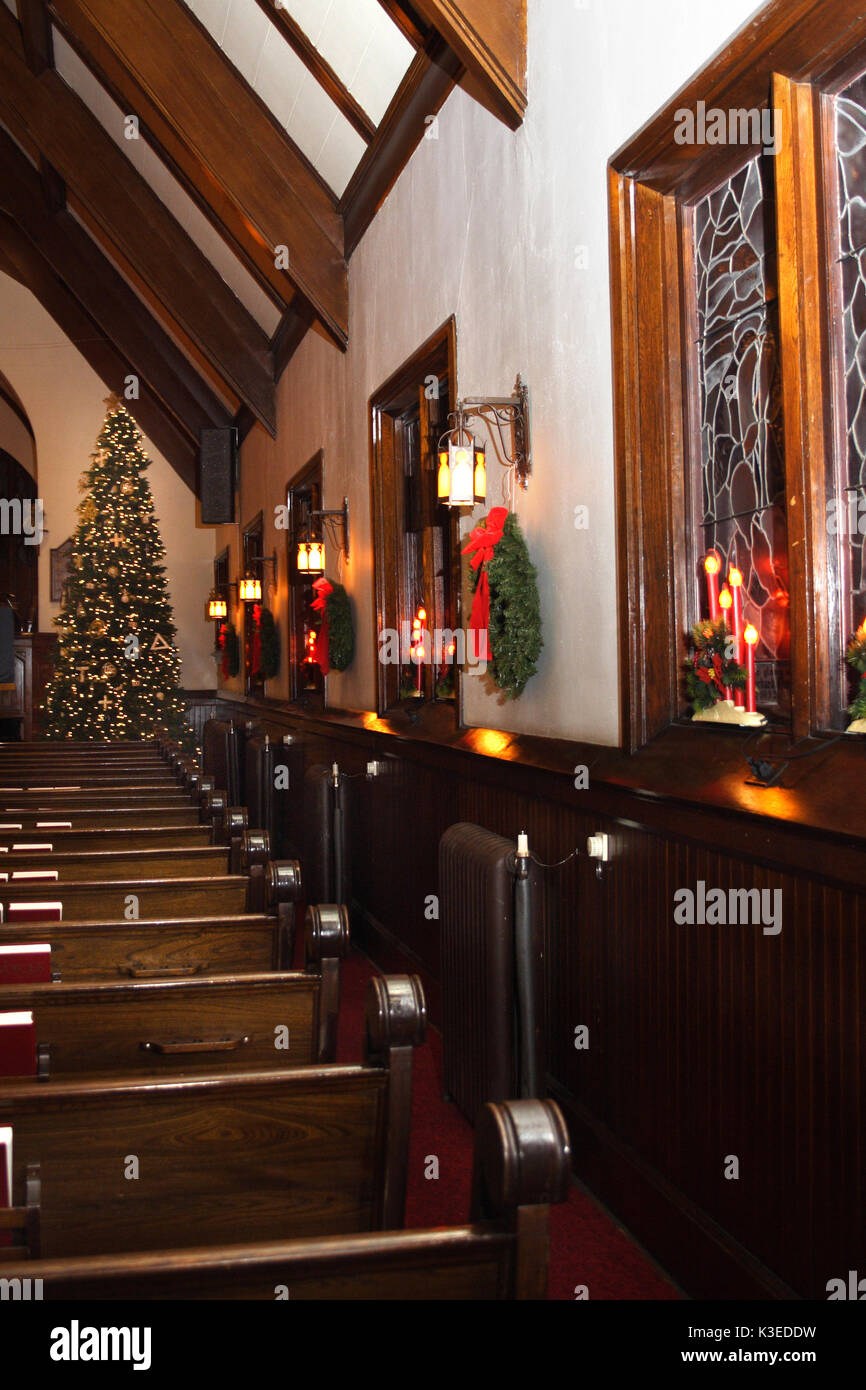 the inside of an old church with christmas wreaths and candles, lights ...