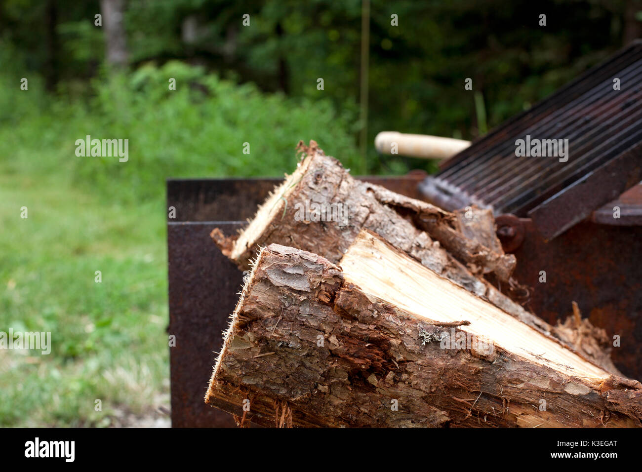 pieces or piles of wood or logs, piled beside a camping ground stove in ...