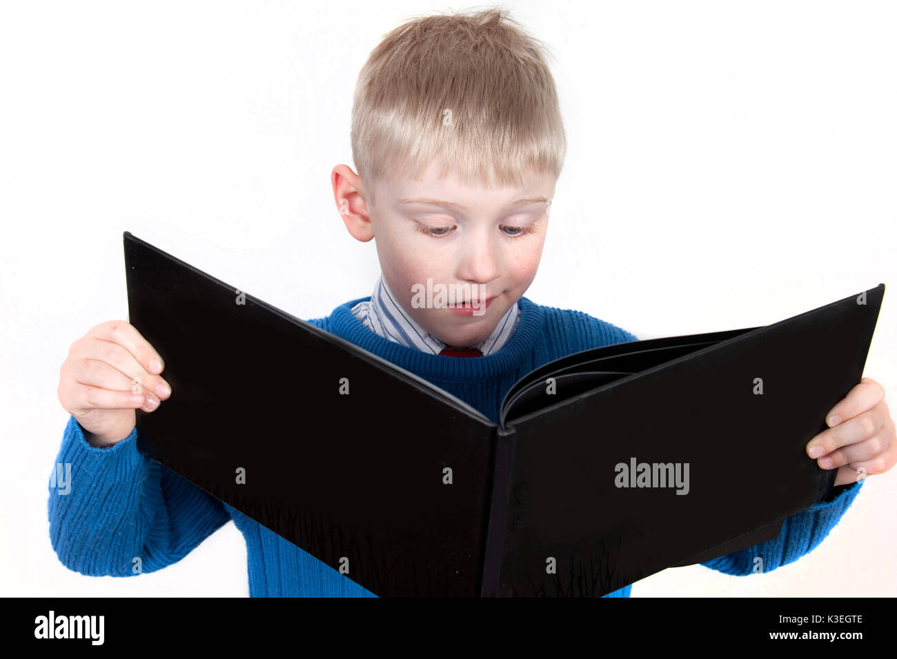 Little boy interested in reading a book Stock Photo - Alamy