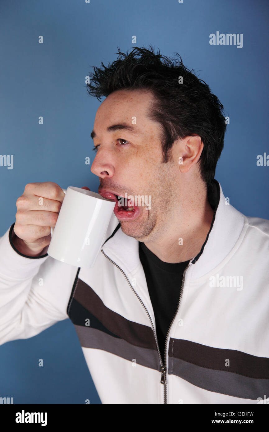 Young man has sleepy face before morning coffee Stock Photo - Alamy