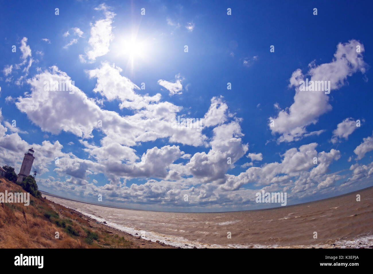Old vintage beacon (lighthouse) at the sea cost with stones and dry ...