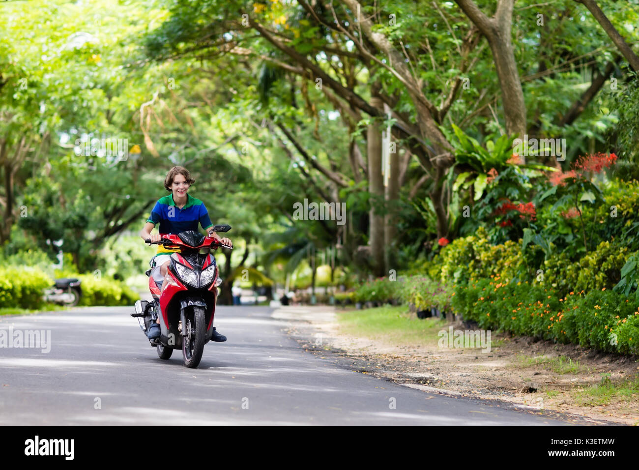 Teenager riding scooter. Teenage boy fun on motorbike ride on his way ...