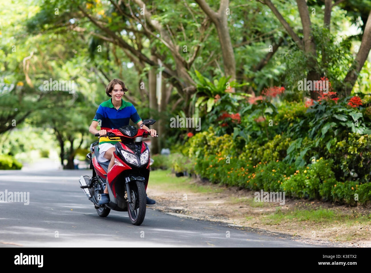 Teenager riding scooter. Teenage boy fun on motorbike ride on his way ...