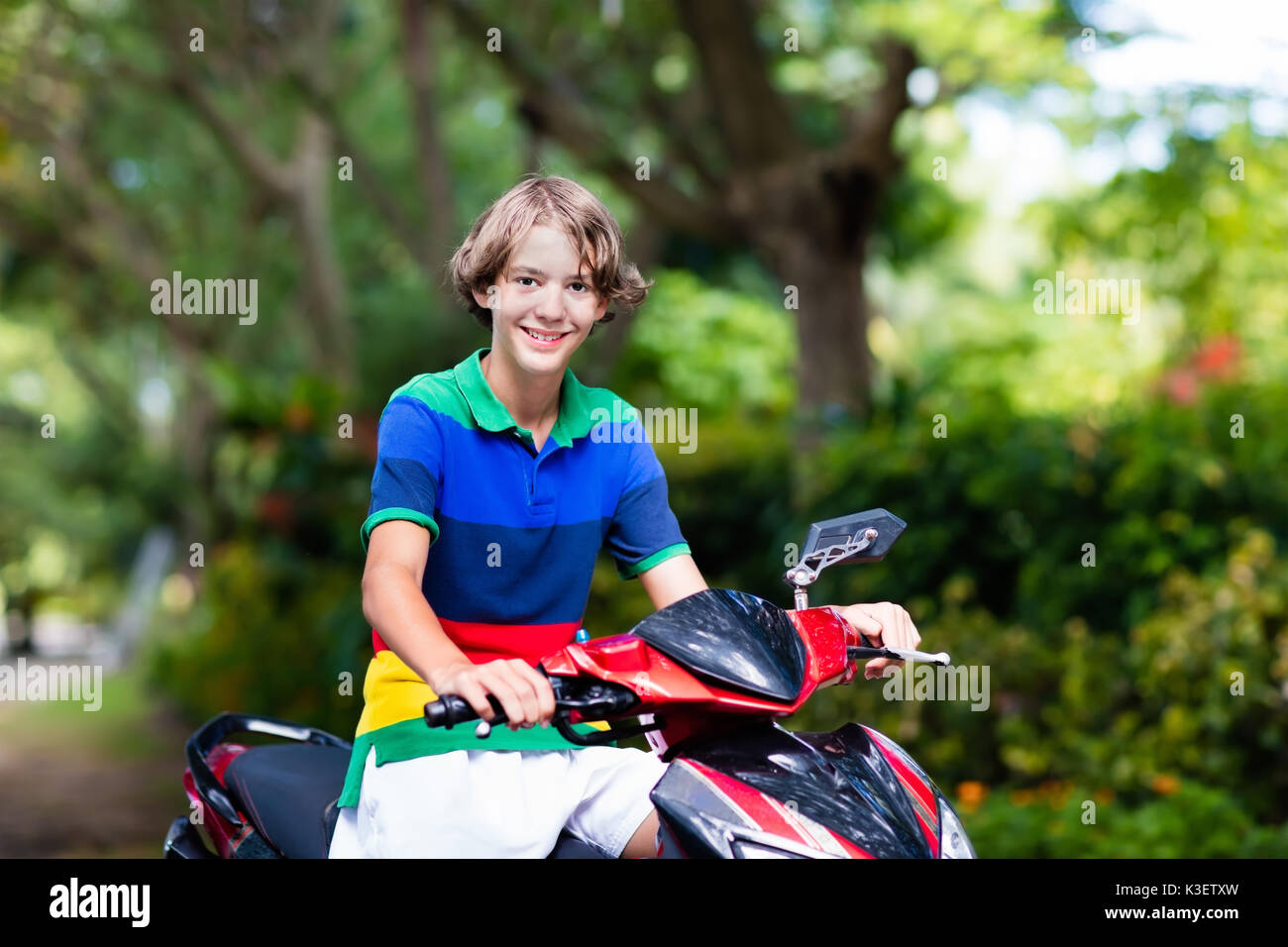 Teenager riding scooter. Teenage boy fun on motorbike ride on his way ...