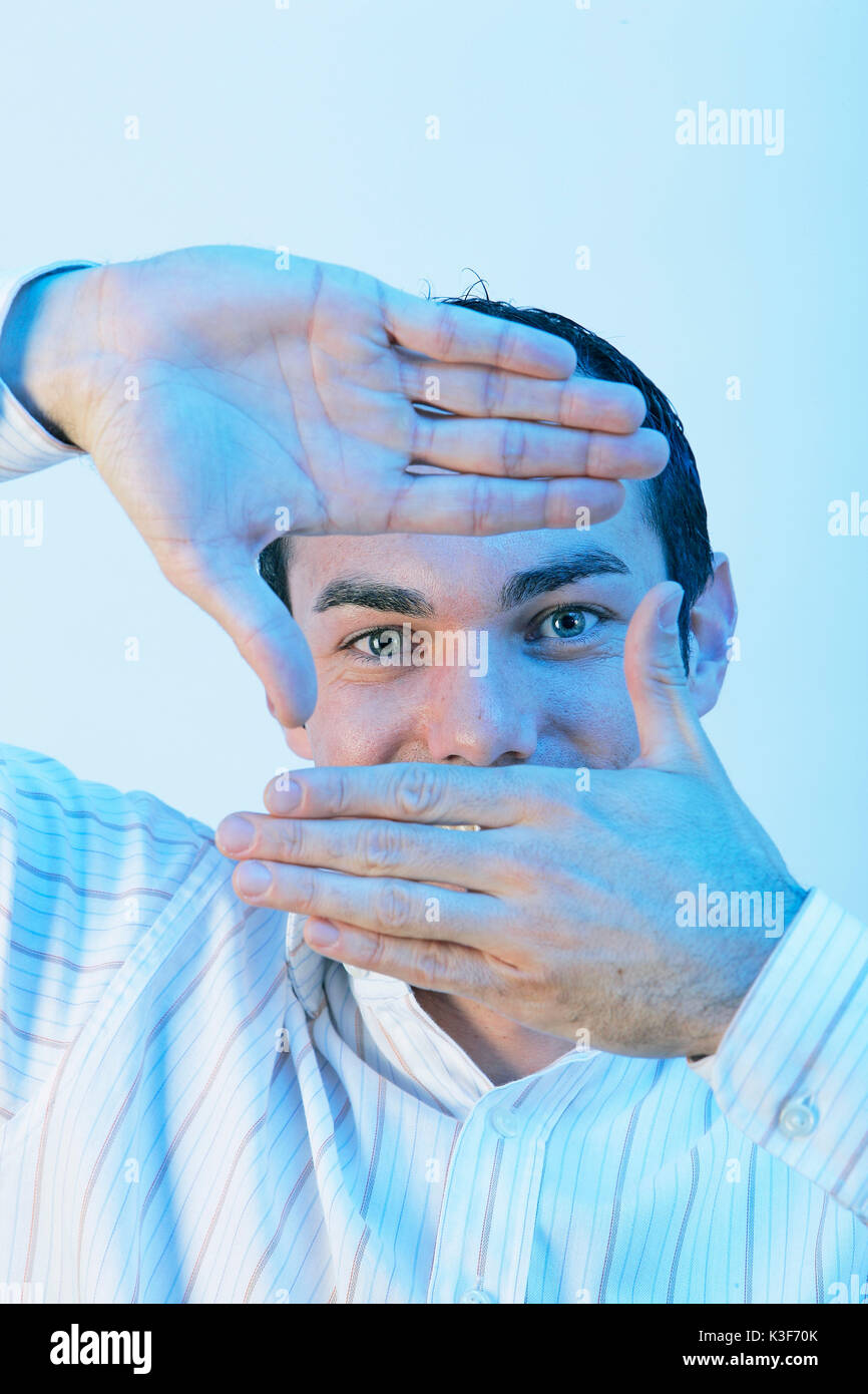 Man forms a rectangle with his hands and looks through Stock Photo - Alamy