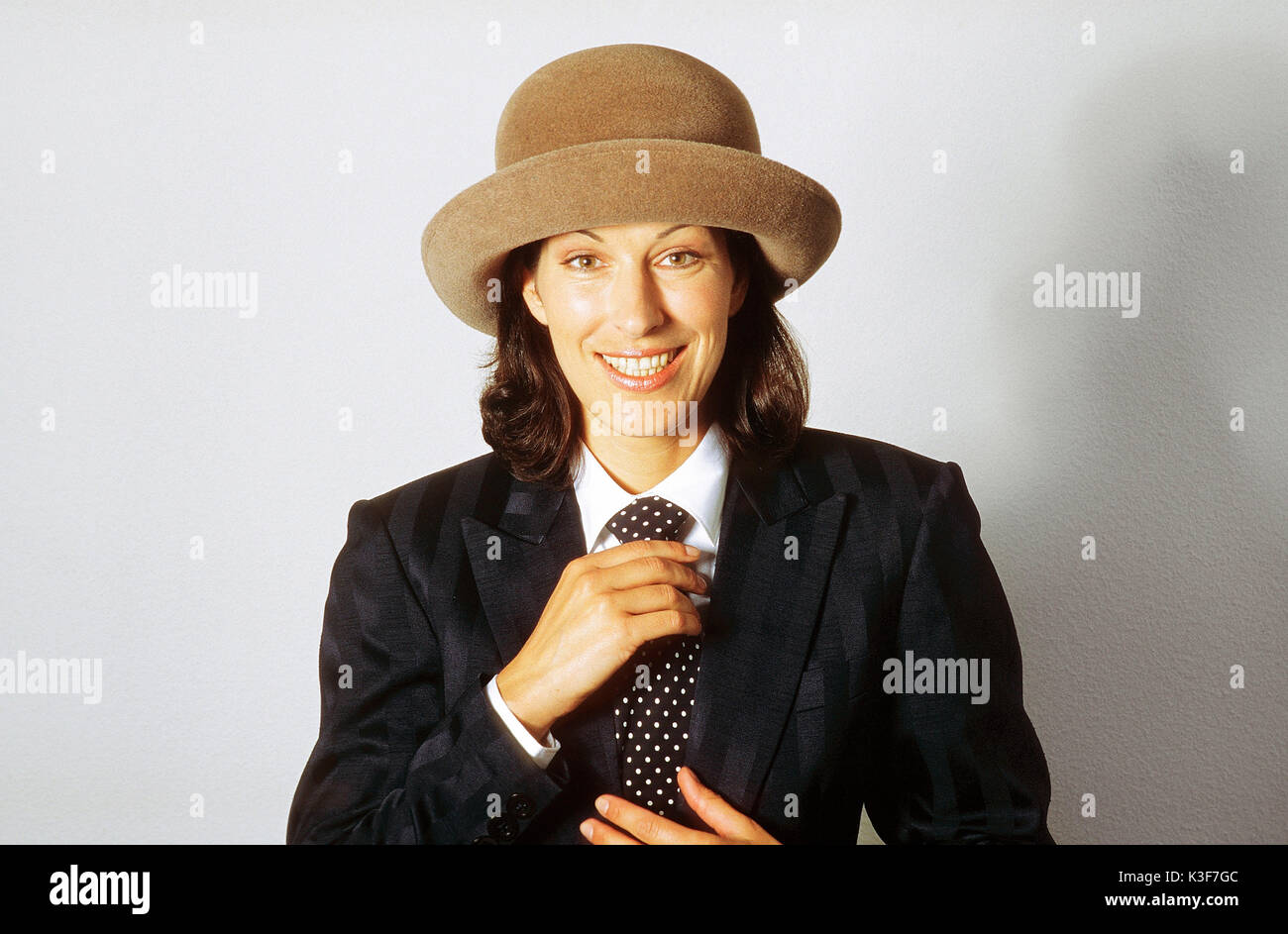 Woman at tie and care straightens tie node Stock Photo - Alamy