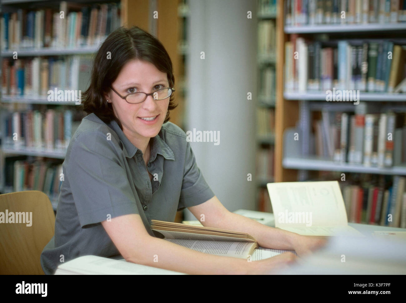 Brown haired young woman in a library hi-res stock photography and ...