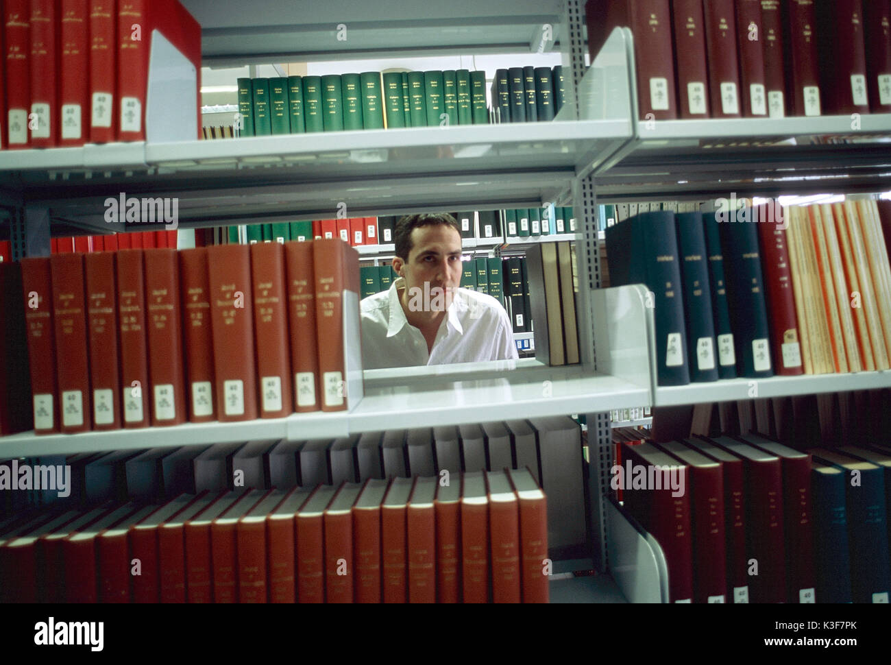 Man at the bookshelf in a library Stock Photo - Alamy