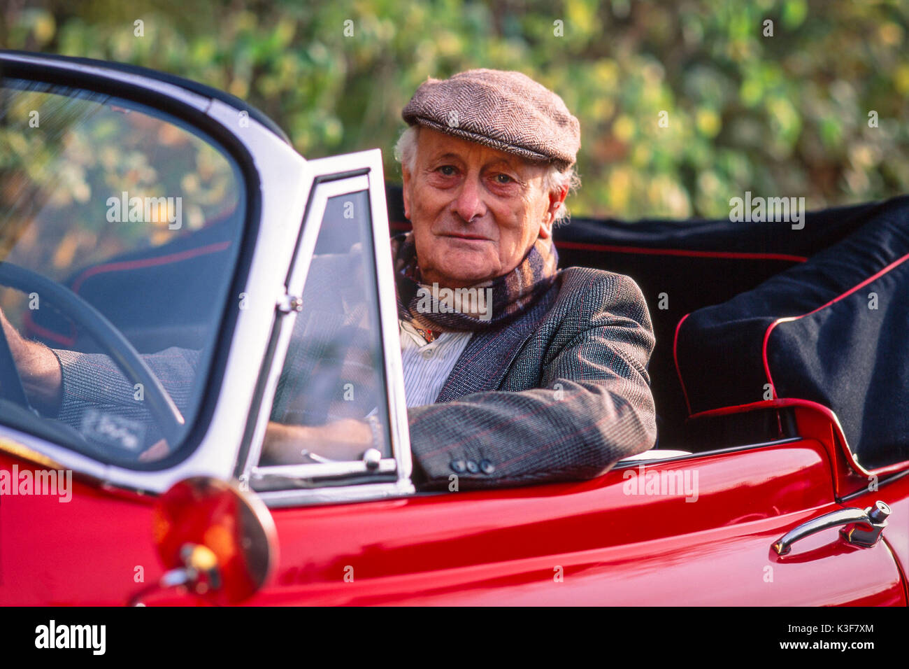 Senior sits in his red old-timer Jaguar cabriolet Stock Photo - Alamy
