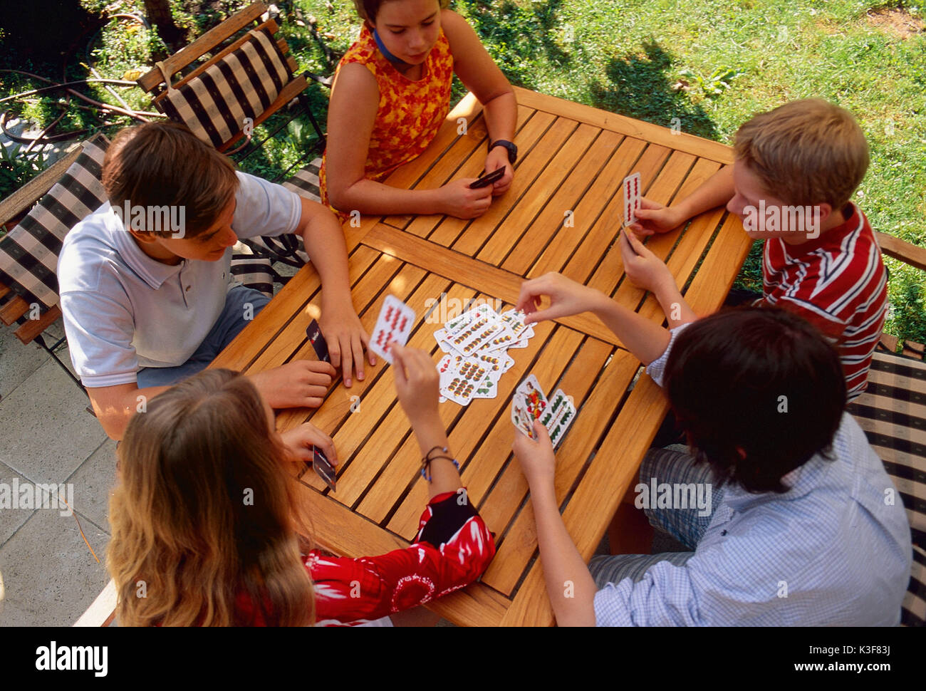 Group of children / of young persons playing cards Stock Photo - Alamy