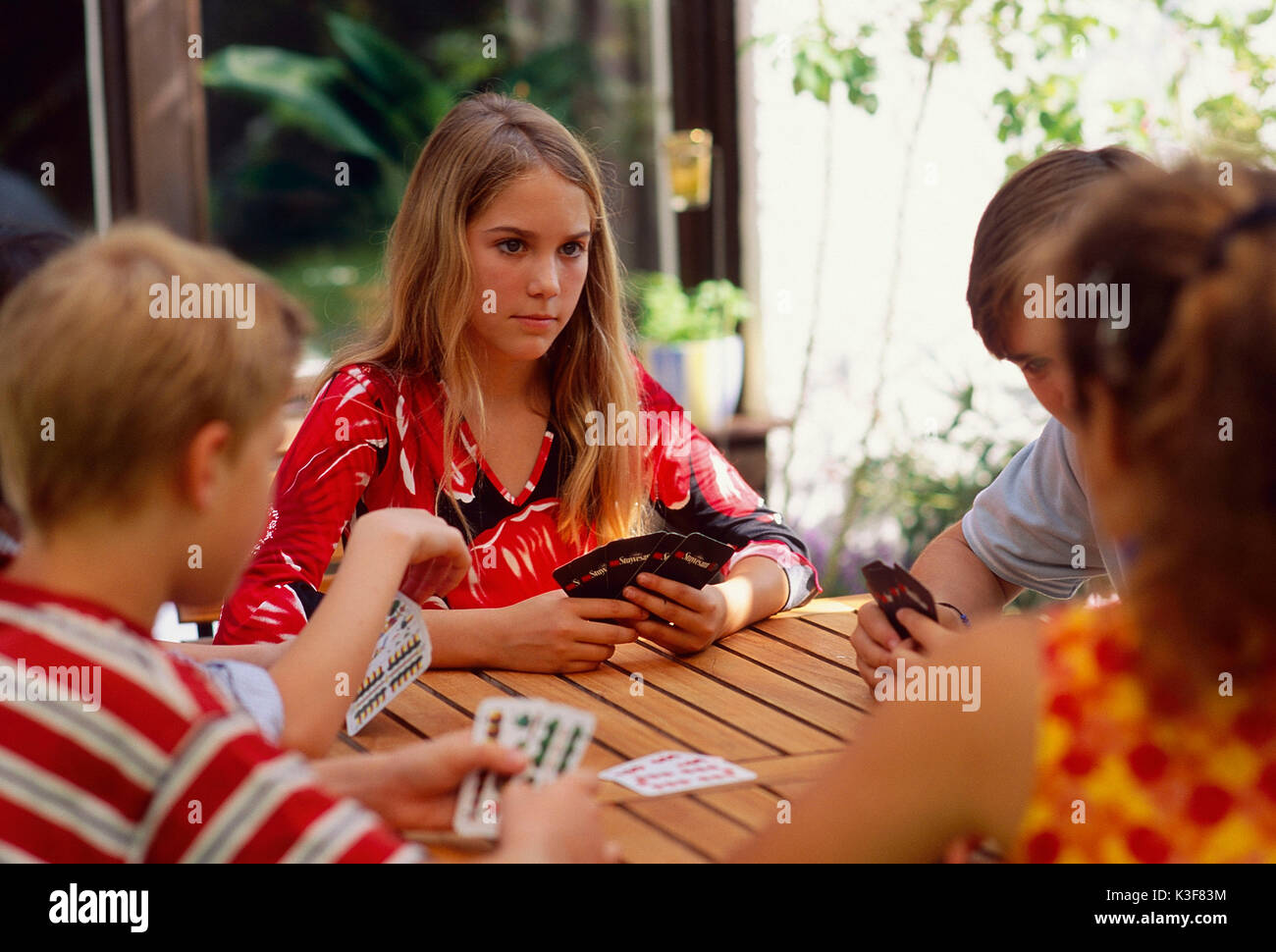 Group of children / of young persons playing cards Stock Photo - Alamy