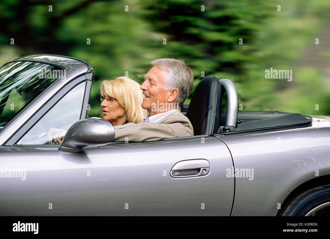 Couple in silver convertible Stock Photo - Alamy