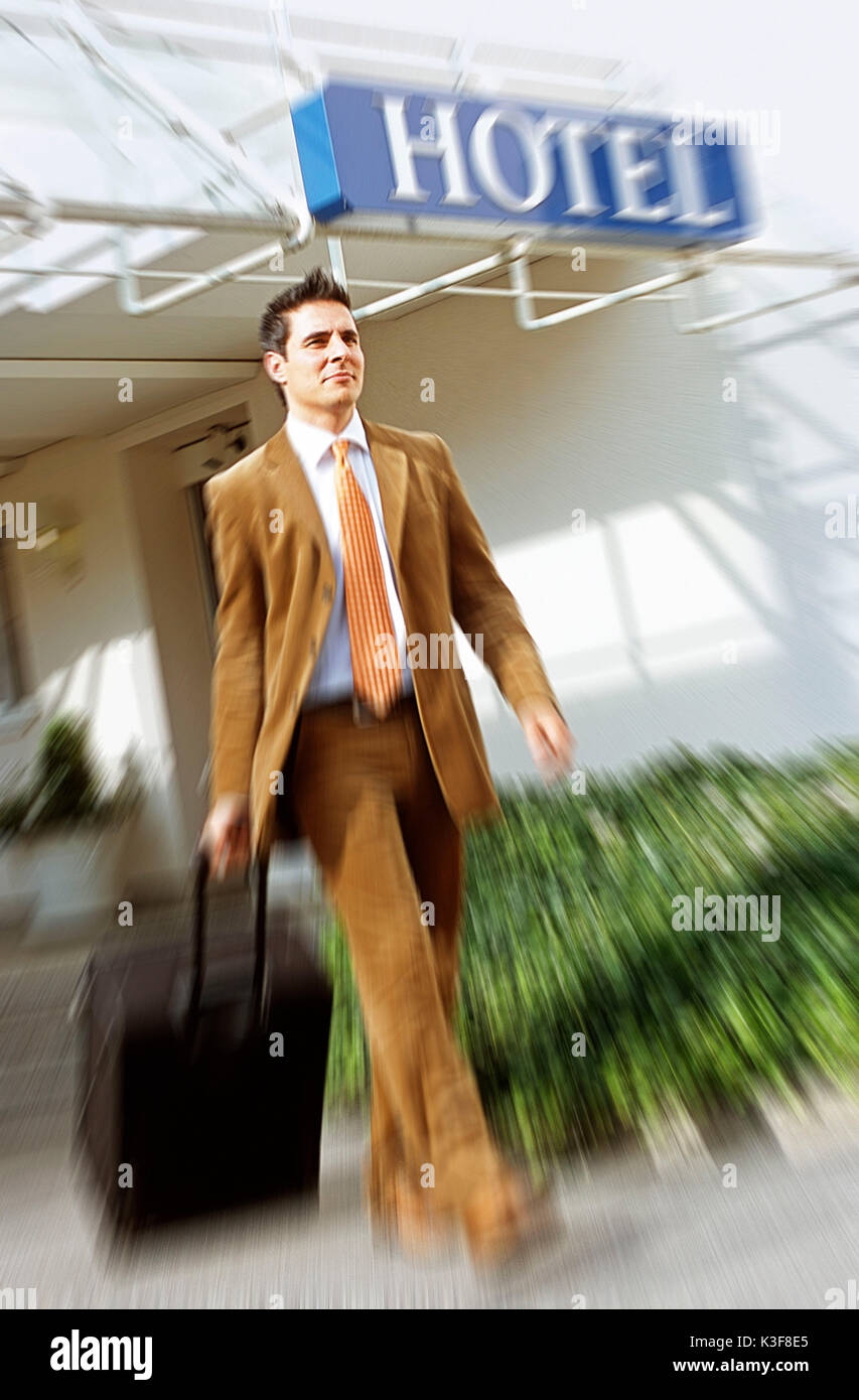 Young businessman in front of hotel Stock Photo - Alamy