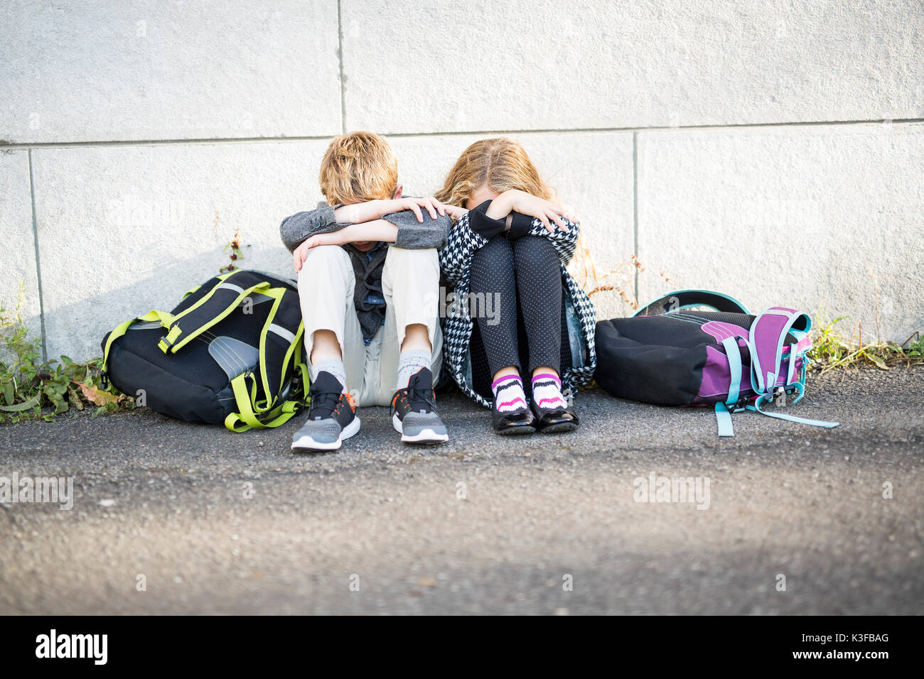 primary students outside at school standing sad Stock Photo - Alamy