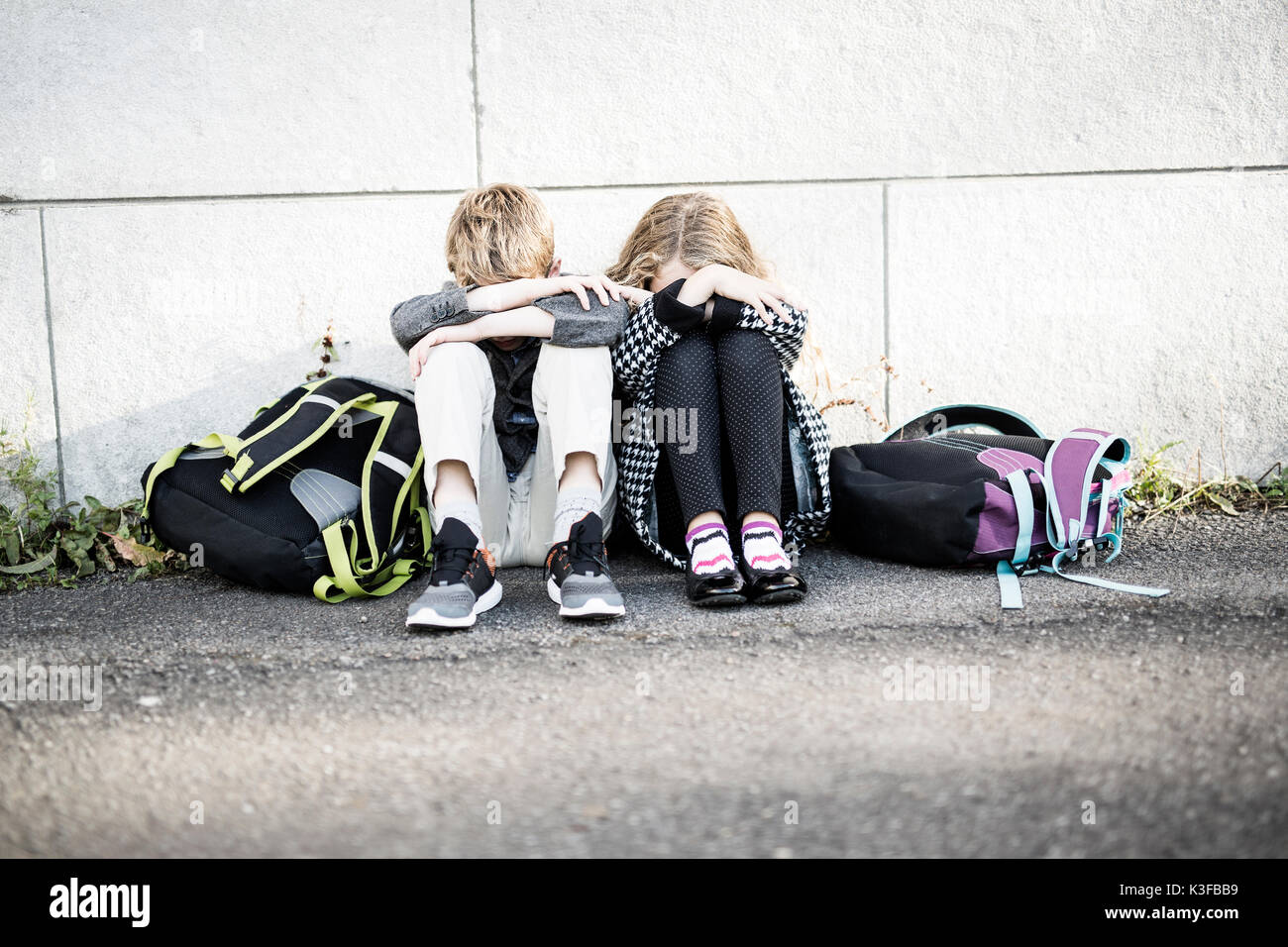 primary students outside at school standing sad Stock Photo - Alamy