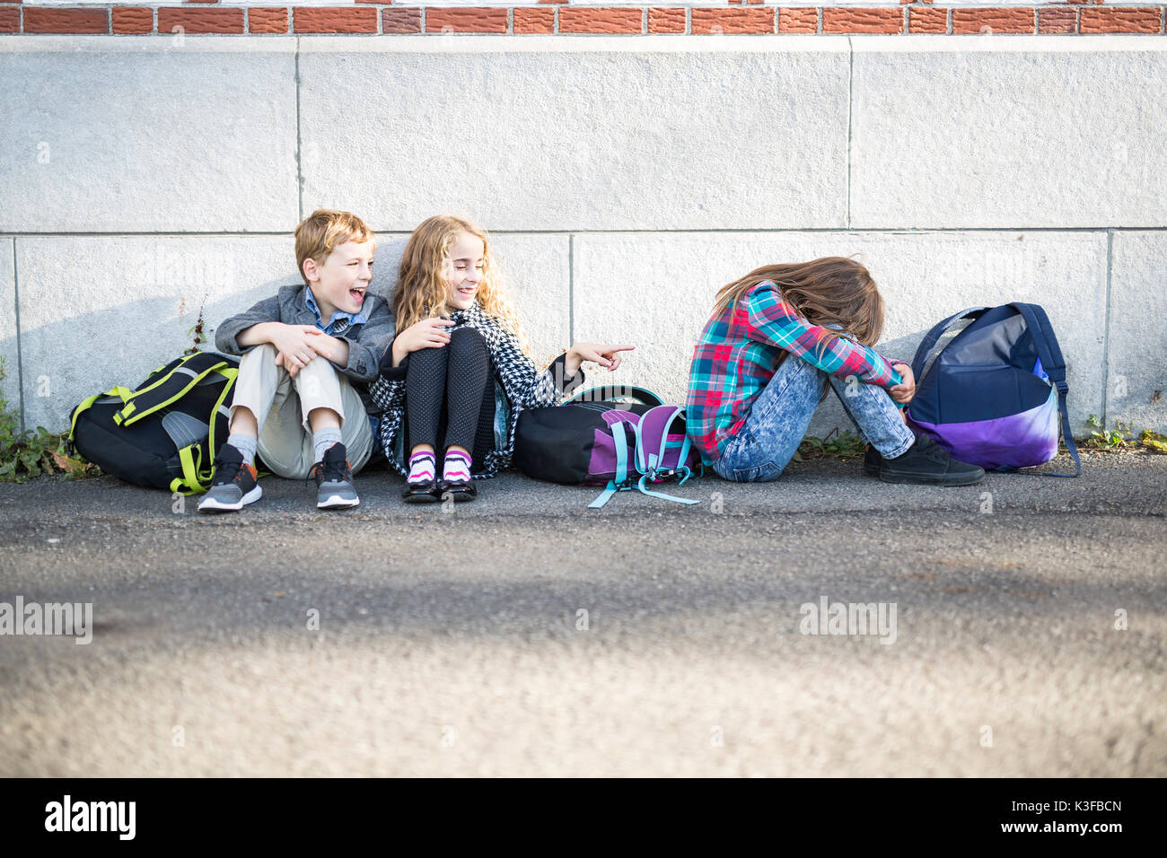 primary students outside at school standing sad Stock Photo - Alamy