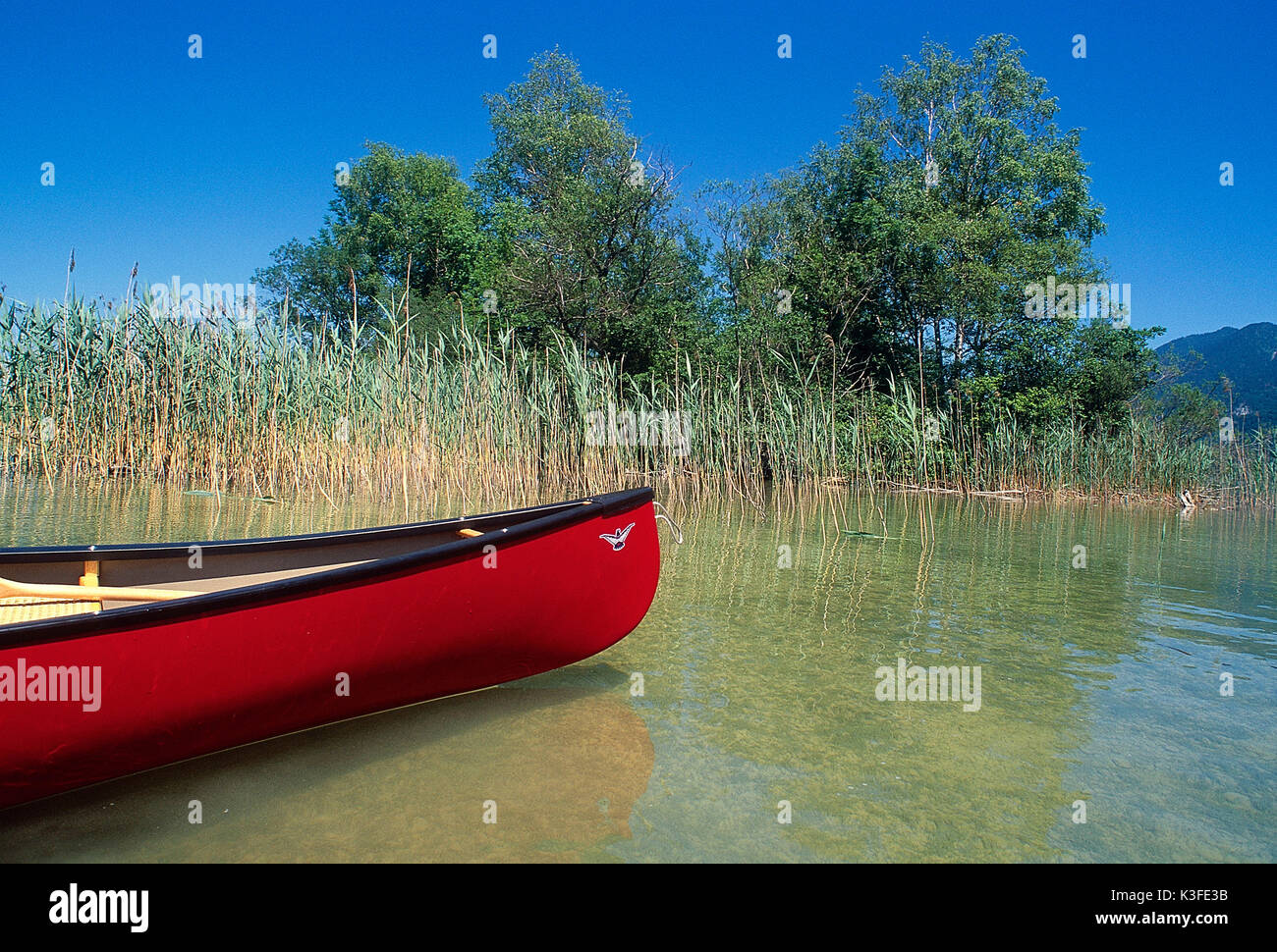 Red canoe at the shallow waters Stock Photo - Alamy