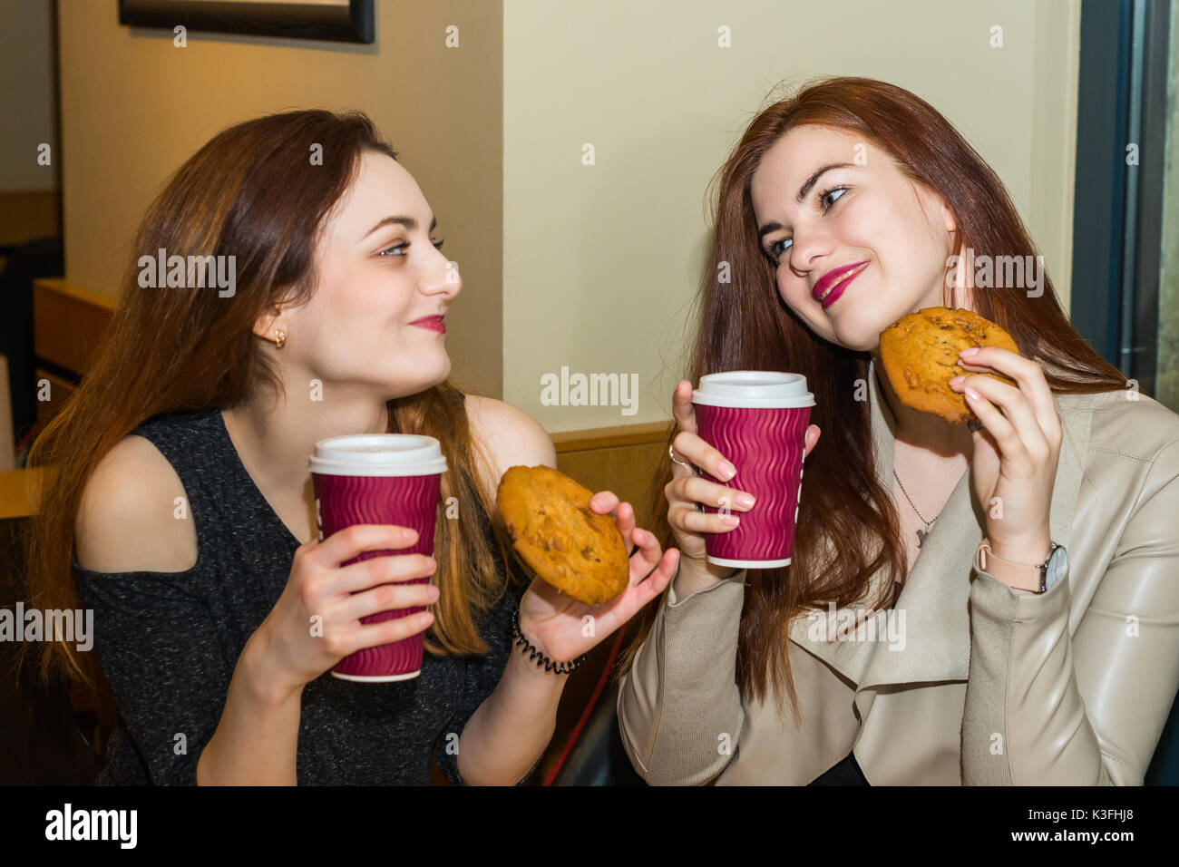 Two young girls talking in a cafeteria Stock Photo - Alamy