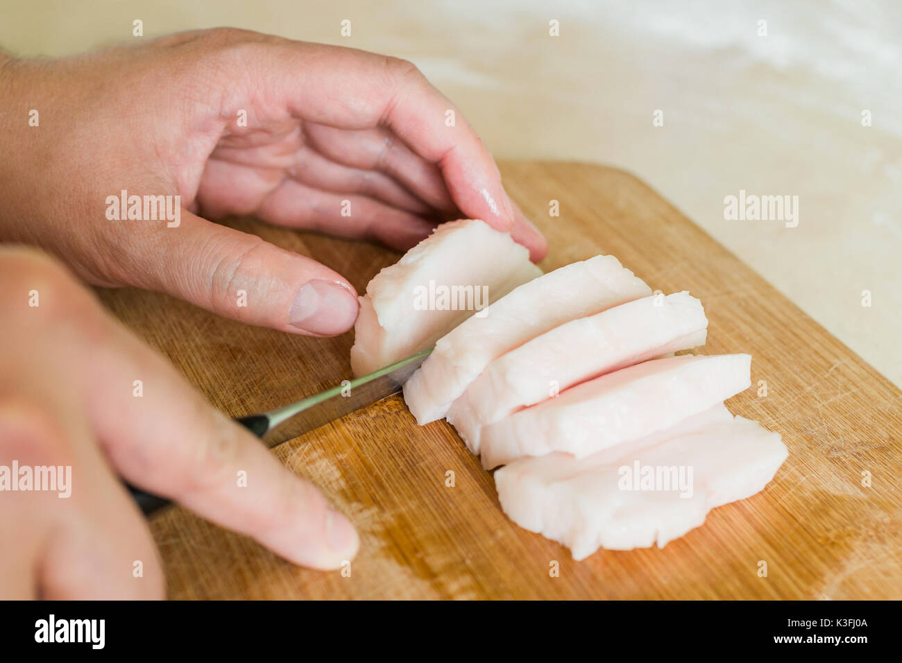 a man cuts raw pork fat into pieces Stock Photo - Alamy