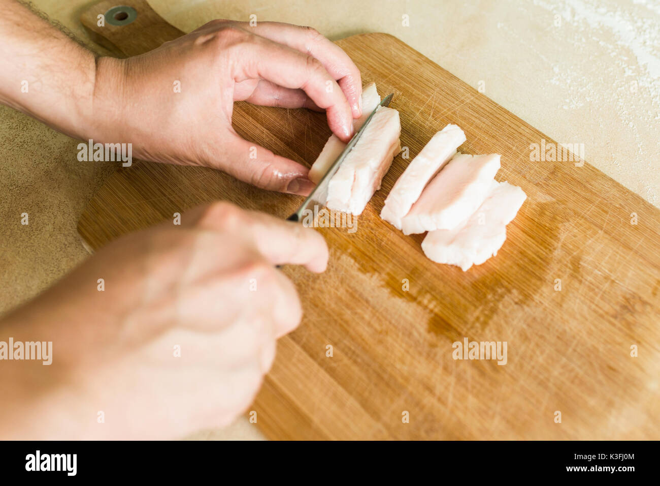 a man cuts raw pork fat into pieces Stock Photo - Alamy
