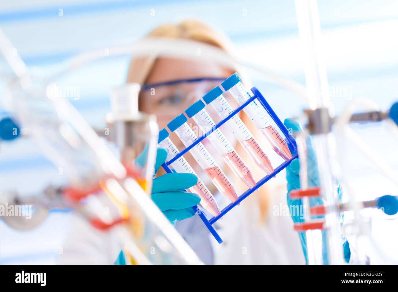Female laboratory assistant with chemical experiment in scientific ...