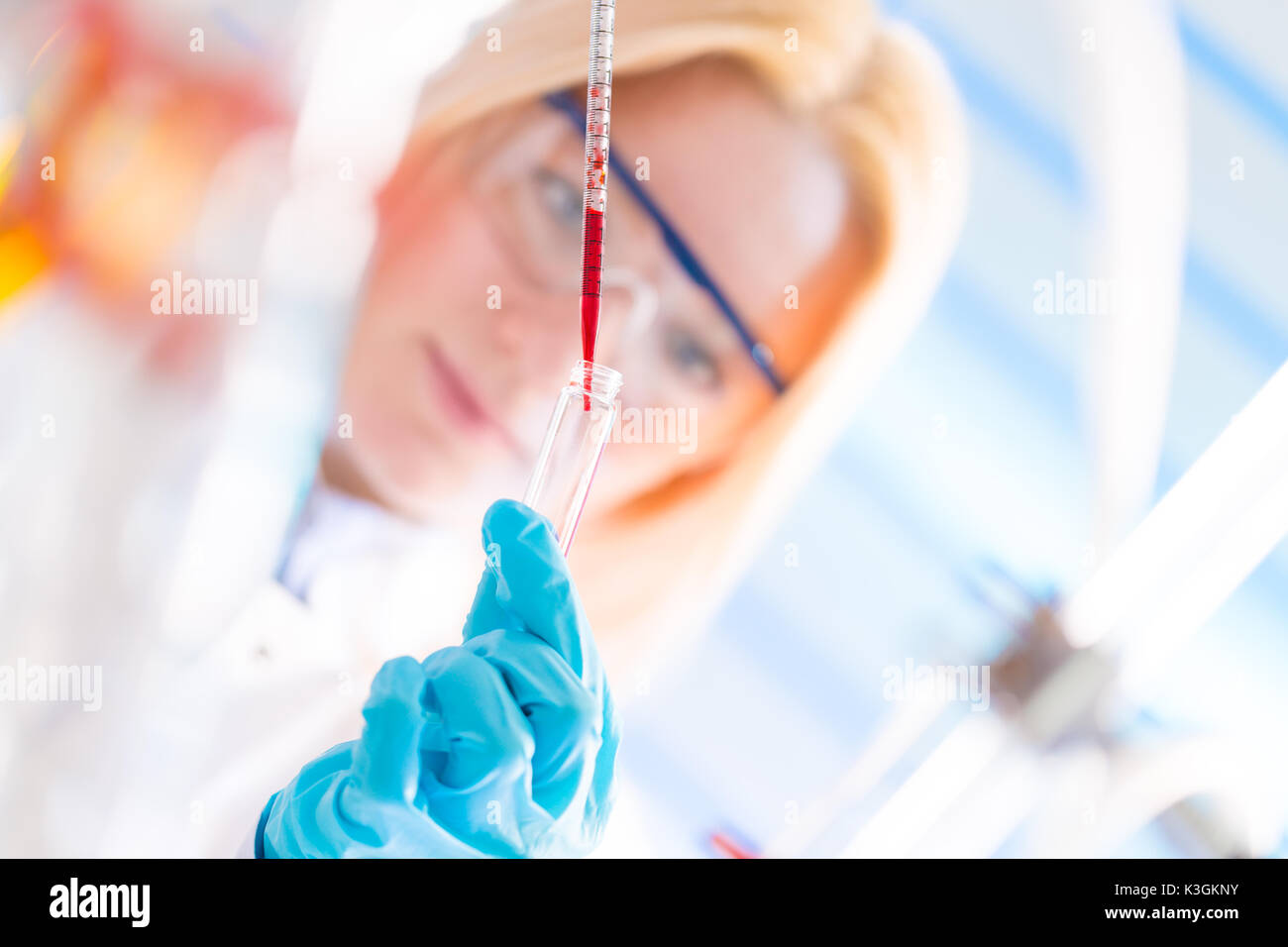 Female laboratory assistant with chemical experiment in scientific ...