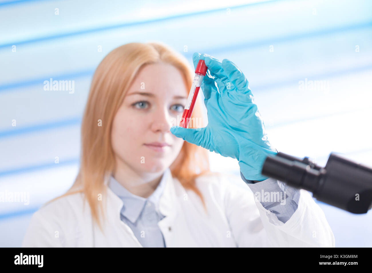 Doctor woman working a microscope. Female scientist looking through a ...