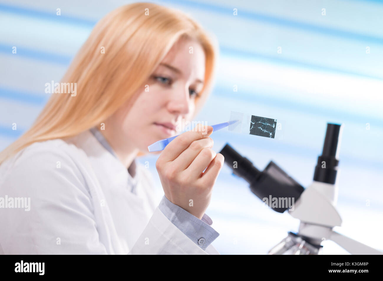 Doctor woman working a microscope. Female scientist looking through a ...