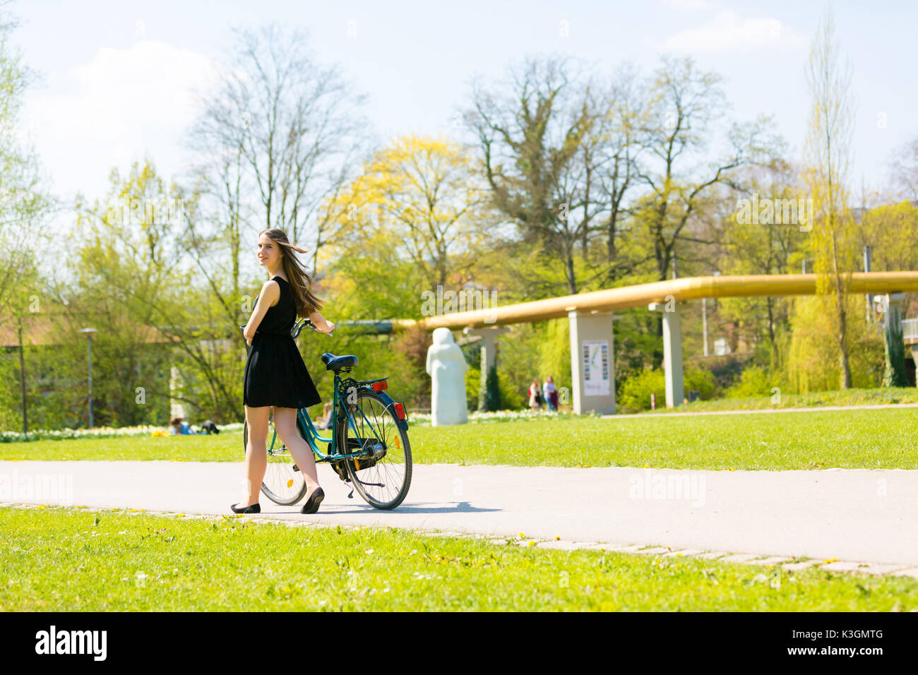 Back view of girl on bicycle wearing on black short dress. Young Woman ...