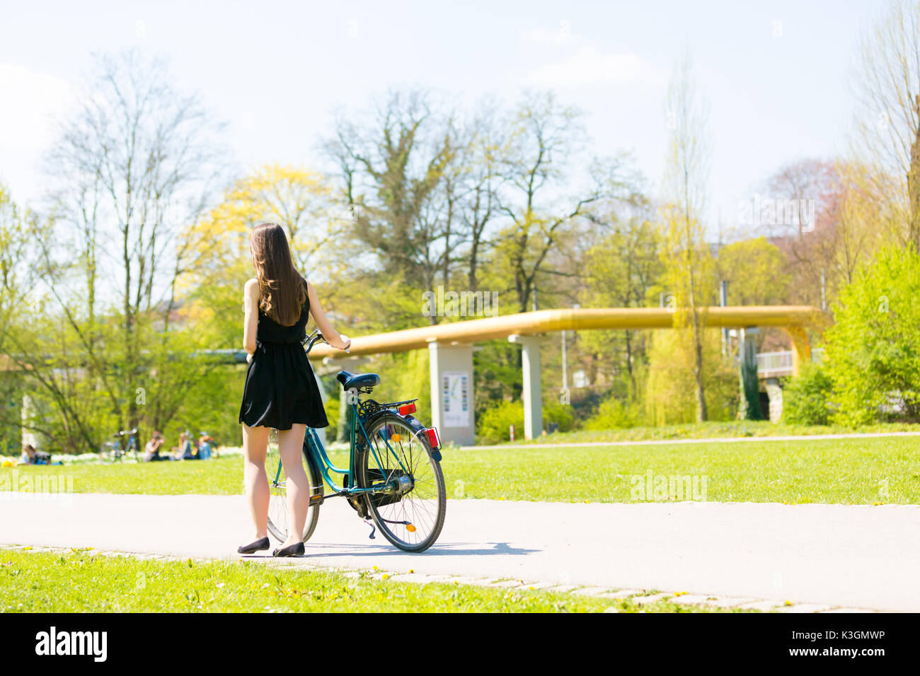 Back view of girl on bicycle wearing on black short dress. Young Woman ...