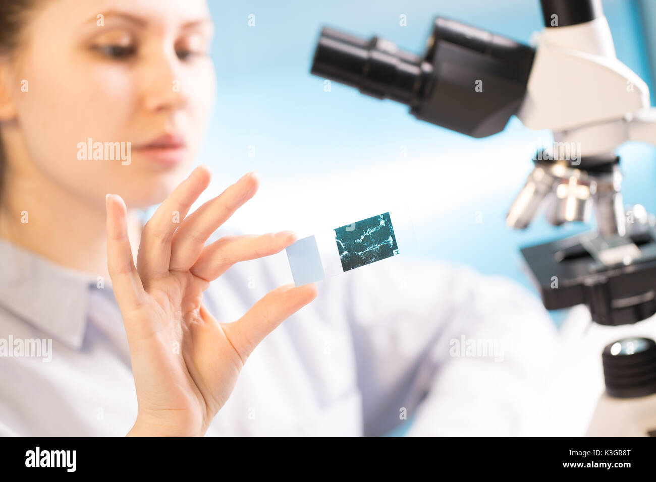 Doctor woman working a microscope. Female scientist looking through a ...