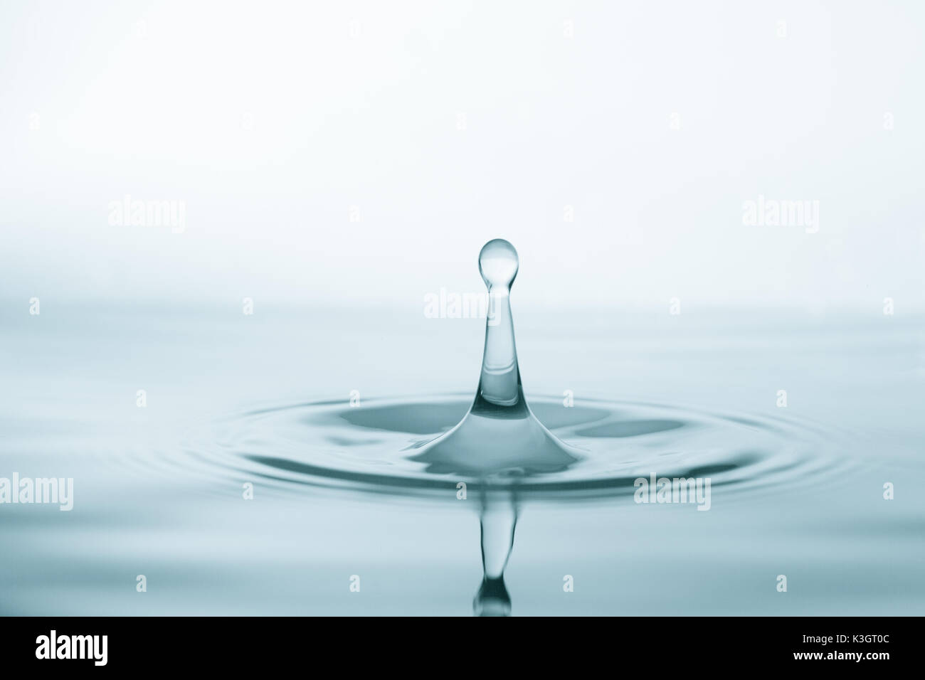 Water drop and splash on water surface on blue background Stock Photo ...