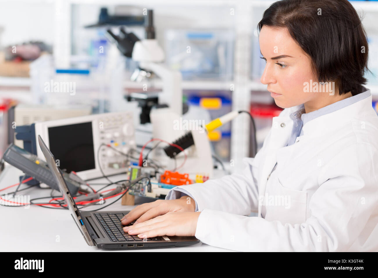 Female laboratory assistant Repairs PCB module for CNC robotics ...