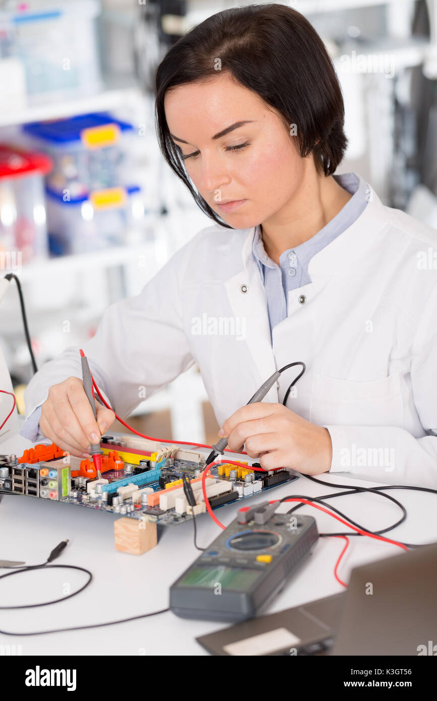 Female laboratory assistant Repairs PCB module for CNC robotics ...