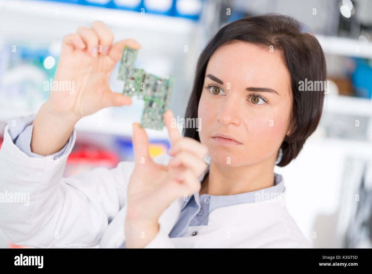 Female laboratory assistant Repairs PCB module for CNC robotics ...