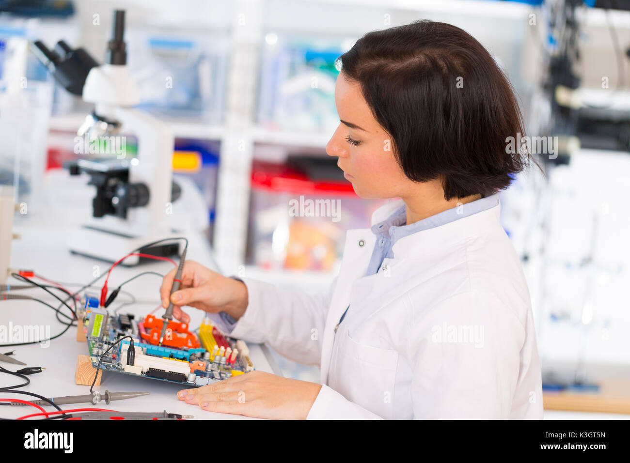 Female laboratory assistant Repairs PCB module for CNC robotics ...