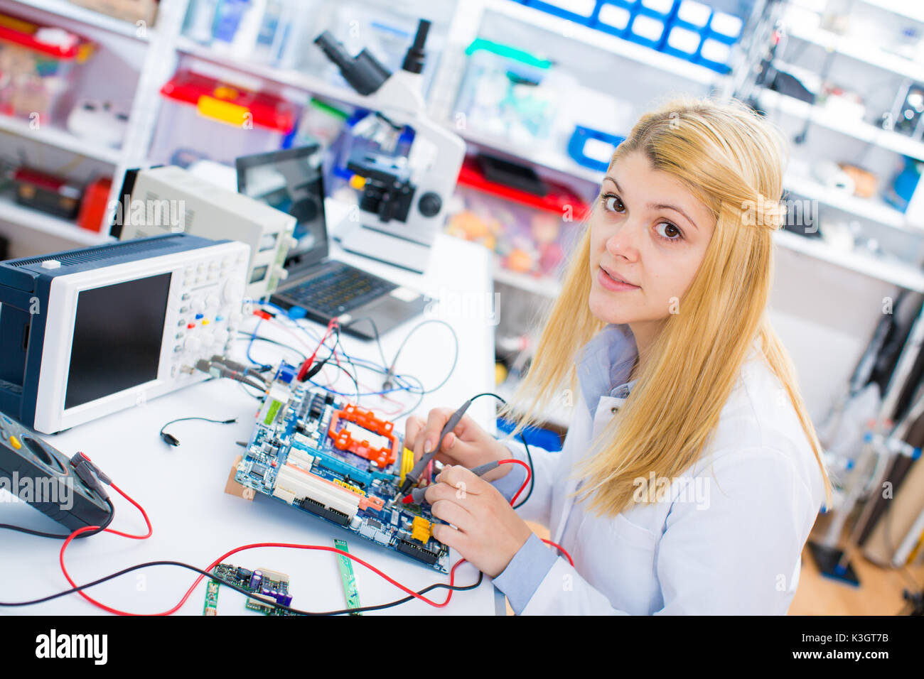 Female laboratory assistant Repairs PCB module for CNC robotics ...