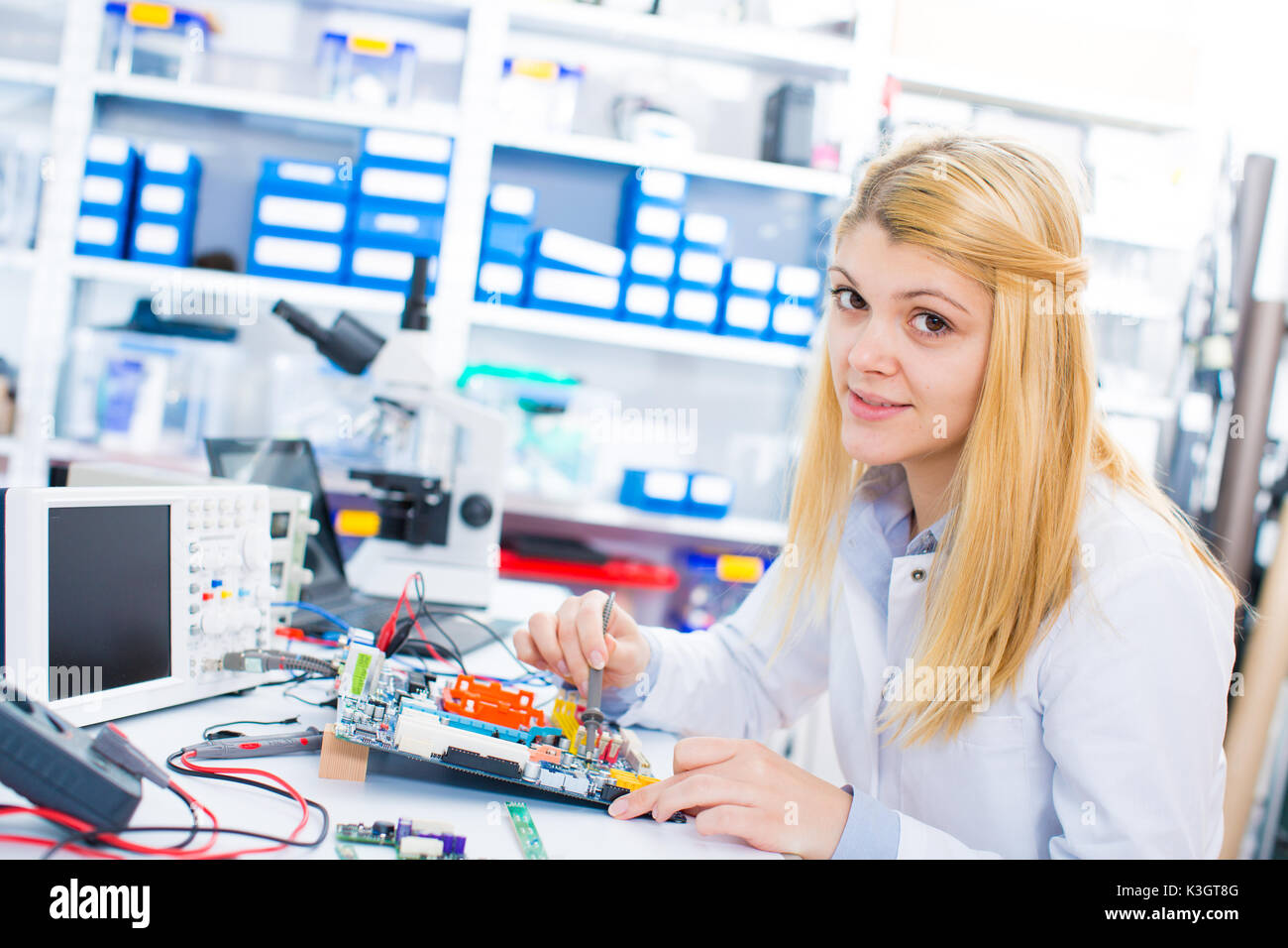 Female laboratory assistant Repairs PCB module for CNC robotics ...