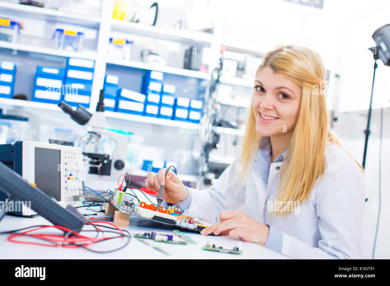 Female laboratory assistant Repairs PCB module for CNC robotics ...